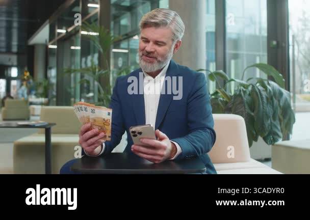 Successful happy rich mature businessman holding smartphone and ...