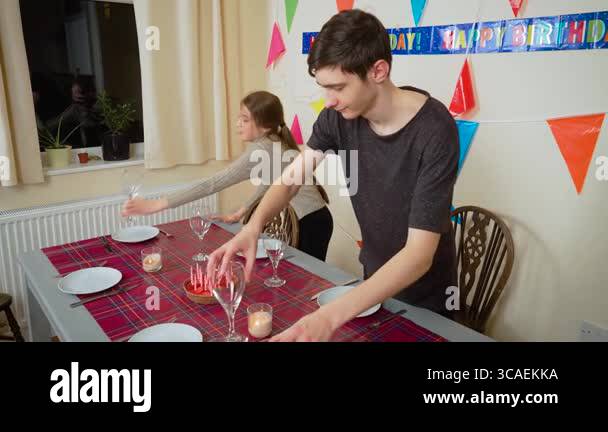 Setting up tableware for birthday celebration. Brother and sister ...