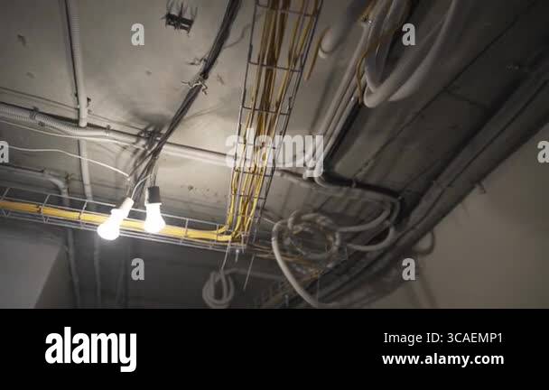 Thick cable bundle snakes along ceiling in steel mesh conduit system ...