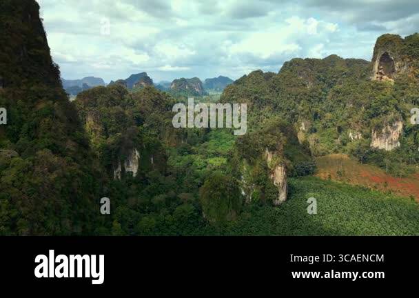 Dramatic drone footage flying over limestone cliffs and green jungle ...