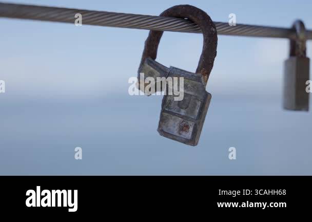 Broken Padlock Hanging on Steel Cable Against Blue horisont. Concept of ...