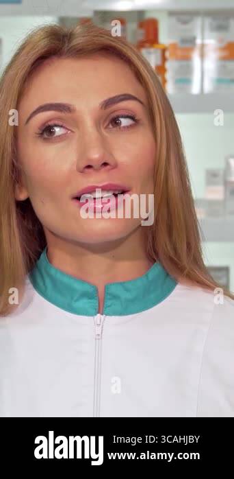 A warm and inviting female pharmacist in a crisp lab coat smiles as she ...