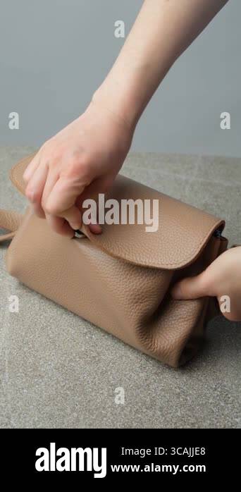 Woman opening and closing magnetic lock of womens handbag, slow motion ...