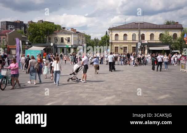 Crowd of people walking and gathering in city square during public ...