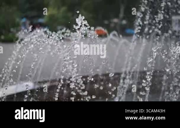 Individual water droplets from a fountain as they glisten and fall. The ...