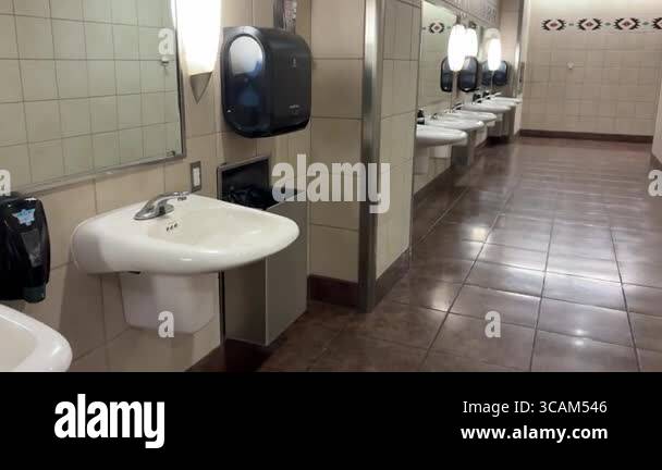 A lively public restroom showcases functional white sinks in neat rows ...