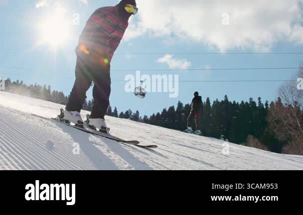 Young male beginner skiers friends enjoy skiing on groomed snow slope ...