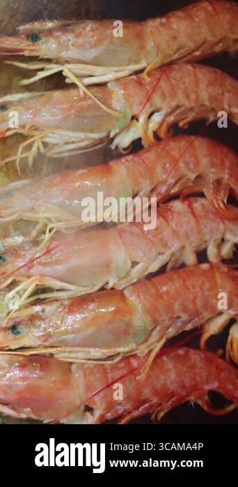 Delicious prawns grilling on a hot surface in a professional kitchen ...
