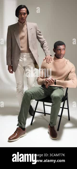 Vertical video: Stylish men in modern outfits posing confidently in ...