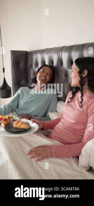 Vertical video: Morning smiles sparking two women sharing tray, sipping ...