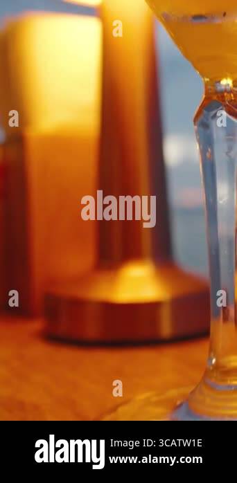 Vertical video. Woman Placing Orchid Flower into Yellow Cocktail in ...