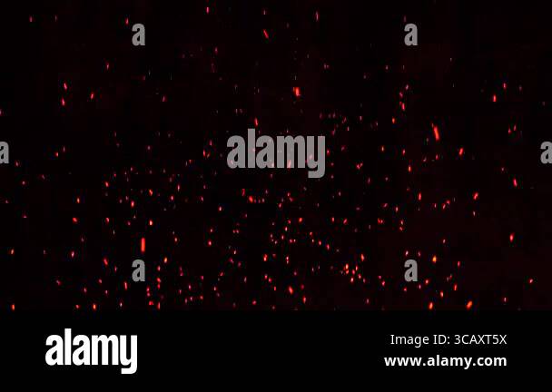 Bright sparks fly rapidly upwards on a dark background, showing bright ...