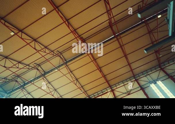A view of a large industrial ceiling with metal beams and panels ...