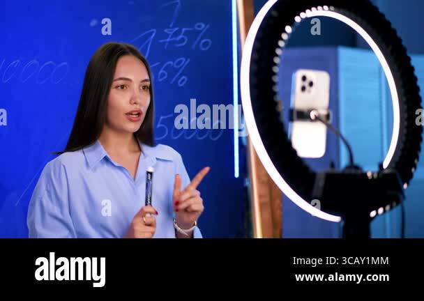 Dynamic online talk by a young woman. A young woman wears a blue shirt ...