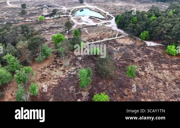 Vast dry land with small pond. A vast, dry landscape features a small ...