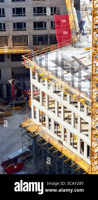Commercial building progress. Workers and machinery are busy at a ...