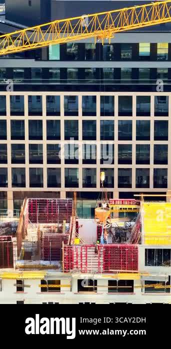 Urban construction site with crane. Workers engage in construction at a ...