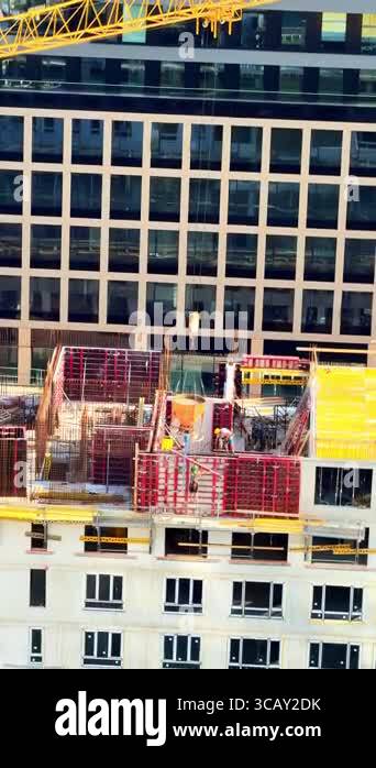 Workers on high-rise site. Workers are actively constructing a high ...
