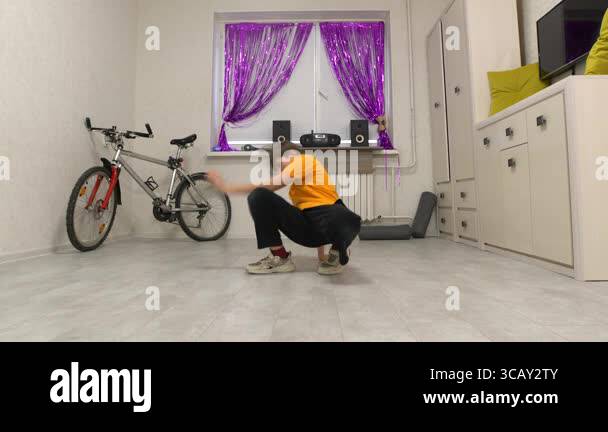 A talented young dancer performs dynamic routines in a well-lit room ...