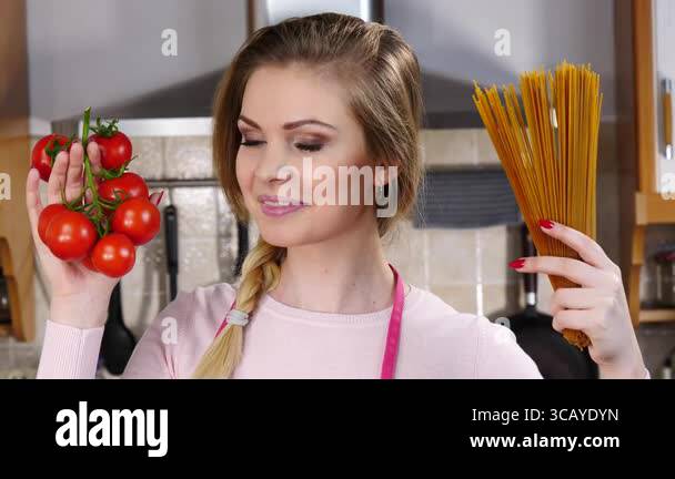 Funny woman thinking about cooking spaghetti holding long pasta and ...