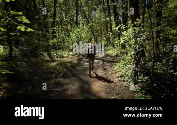 Frightened woman running away from serial killer in forest. Terrified ...