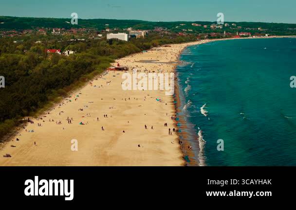 Sandy beach stretching along turquoise sea. Coastal shoreline filled ...