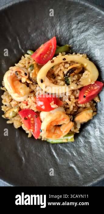 Rice and prawns or paella, a meal with seafood and vegetables. Cooked ...