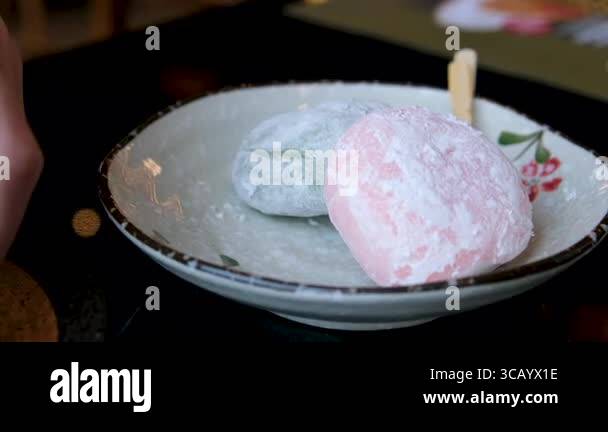Soft pink mochi filled with strawberry and white chocolate, sliced for ...