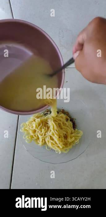 Witness the simple process of preparing instant noodles. This close-up ...