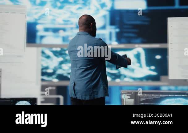 Young professional engineer focused on coding with tablet at an innovation hub, using ...