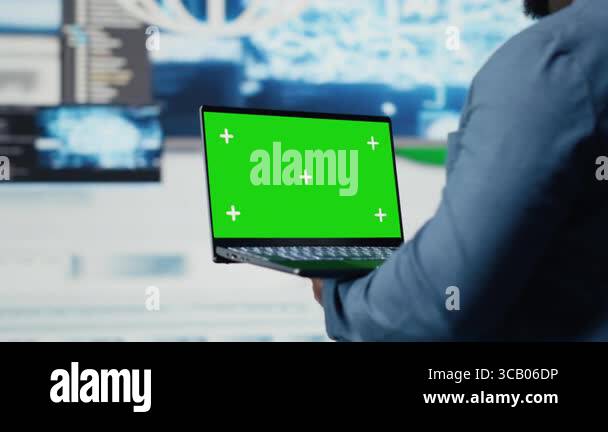 Black engineer works on binary code with chroma key on laptop ...
