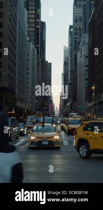 Vertical video of yellow taxi driving through Manhattans illuminated ...