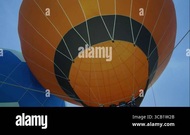 Bottom view of a hot air balloon being inflated with flame against a ...
