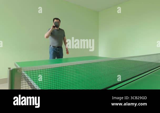 Man playing competitive table tennis with red paddle during ...