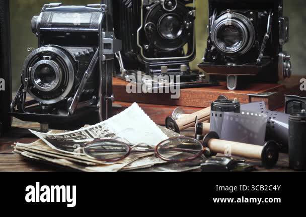 Old cameras in a composition on a wooden background, slowly moving in a ...
