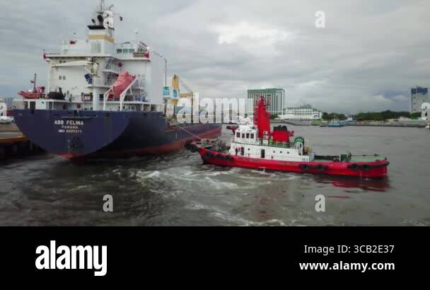 Aerial of Two Tugboats Pulling a Cargo Ship, Manila, Philippines Stock ...