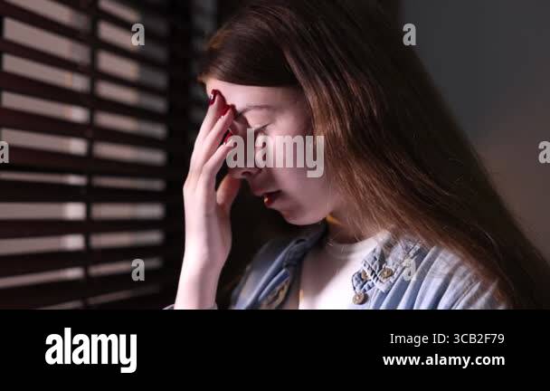 Stressed teenage girl near window at home Stock Video Footage - Alamy