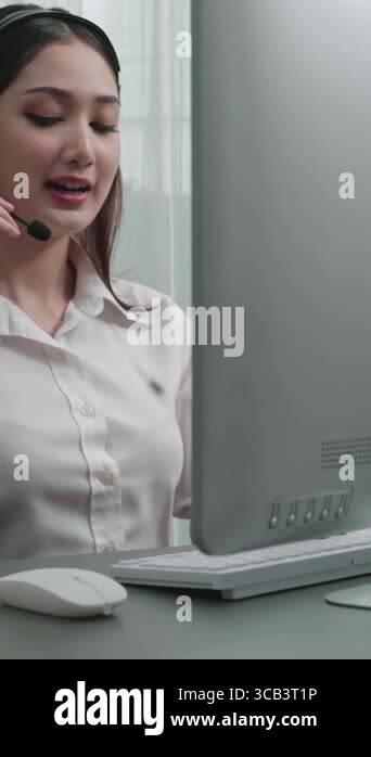 Asian customer support operator wearing headset and microphone working ...