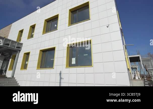 Building facade near completion shines with square ceramic tiles. Sleek ...