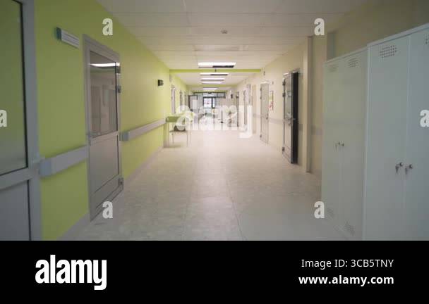 Wide hospital corridor appears pristine and organized. Light bounces ...