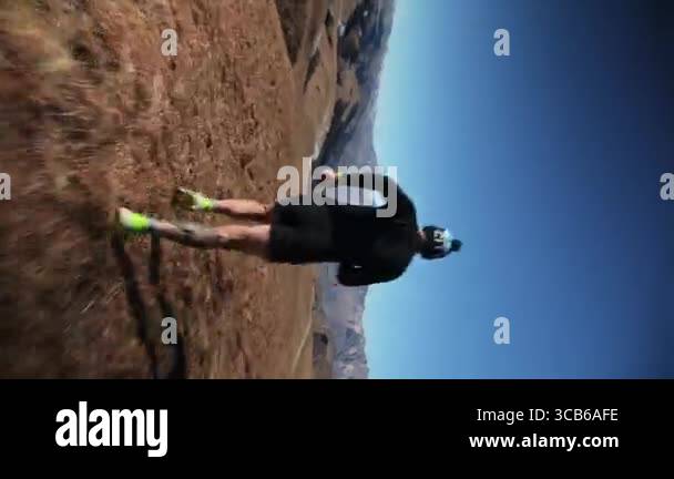 Vertical video live shaking running after athlete runner in mountains ...