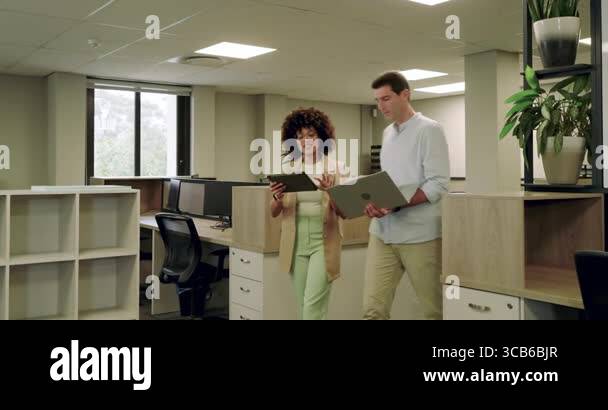 Diverse coworkers in office matching data on devices, high-fiving and ...