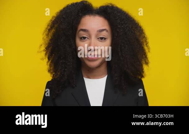 Young woman with natural curly hair gives a subtle nod of approval ...