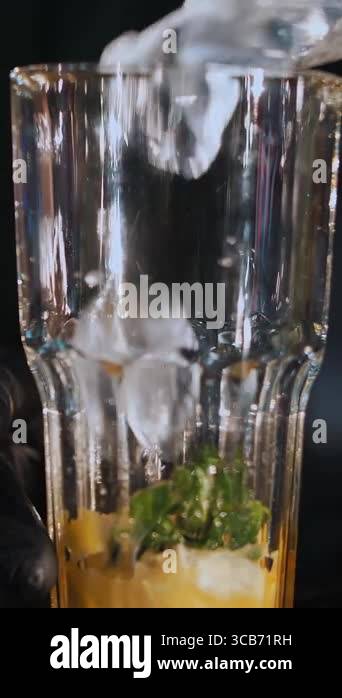 Cocktail. Bartender makes a cocktail. close-up. The bartender pours ice cubes into a glass Stock ...