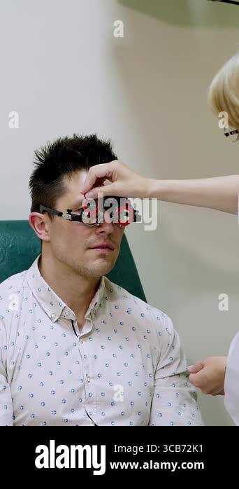 Female Optometrist Doing Sight Testing For Patient In Hospital with ...