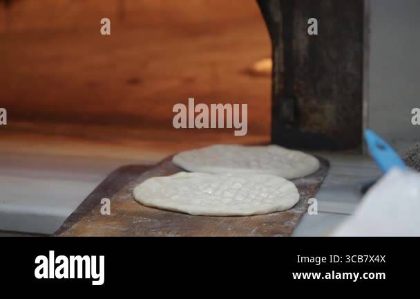 Fresh bread is being prepared in a traditional baking oven at a local ...