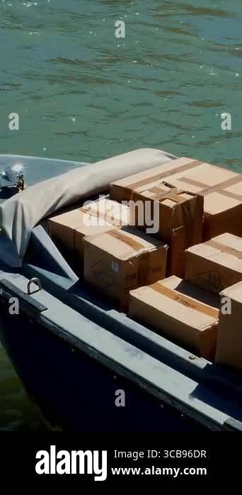 VENICE, ITALY - JULY 7, 2018: close-up, boat, full of boxes, parcels ...