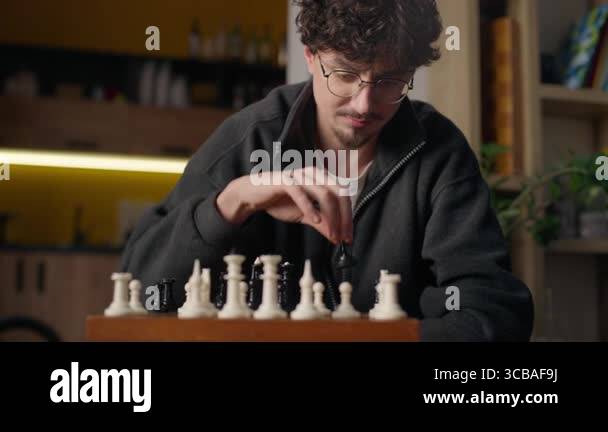 Focused Hispanic guy player playing chess mind game at home hipster ...
