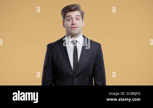 Man in suit looks directly at camera, taps temple, encouraging critical ...