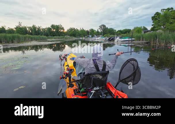 Kayak fishing game, angler at weedy lake pond, fishing pdl kayak during ...